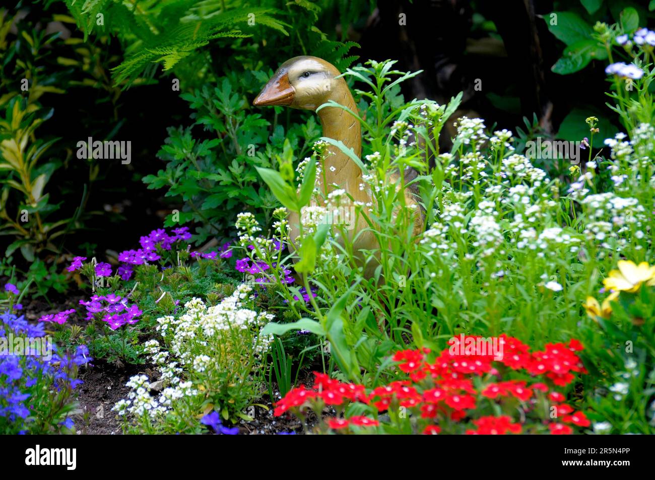 Garden figure: Ceramic goose in a flower garden Stock Photo - Alamy