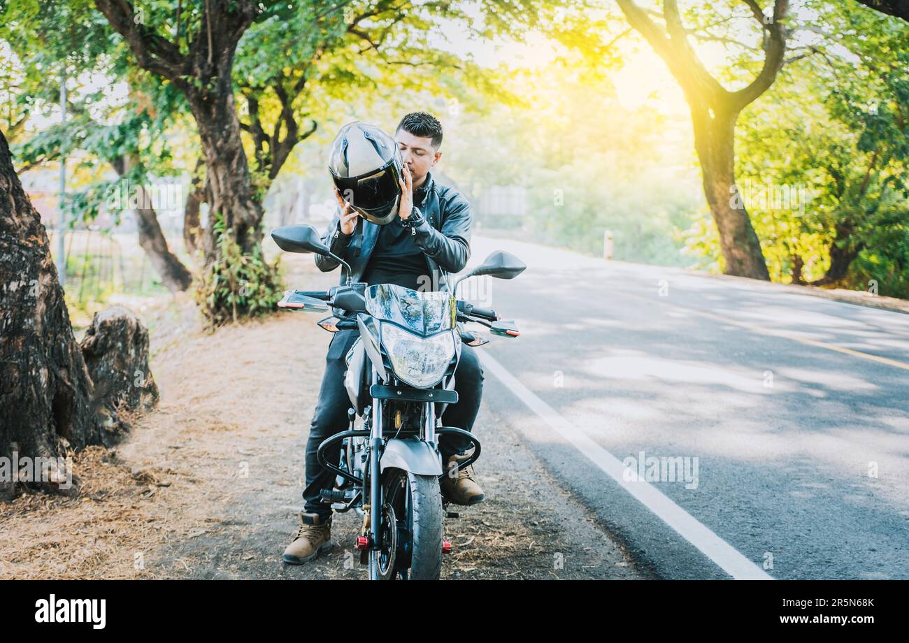 Close-up of motorcyclist man putting on safety helmet. Biker motorcycle ...