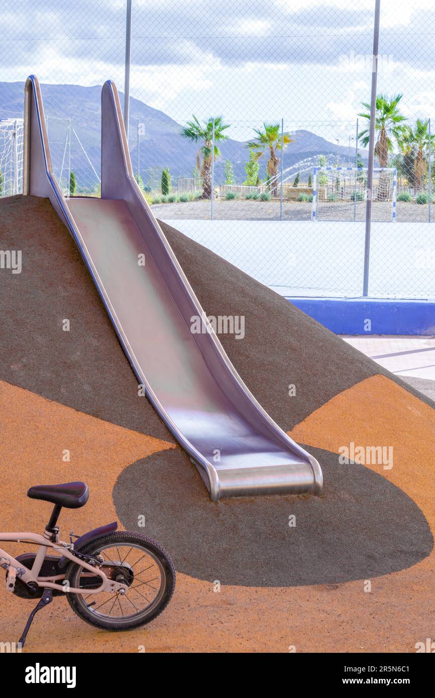 Slide and bicycle in a playground, playground equipment for children ...