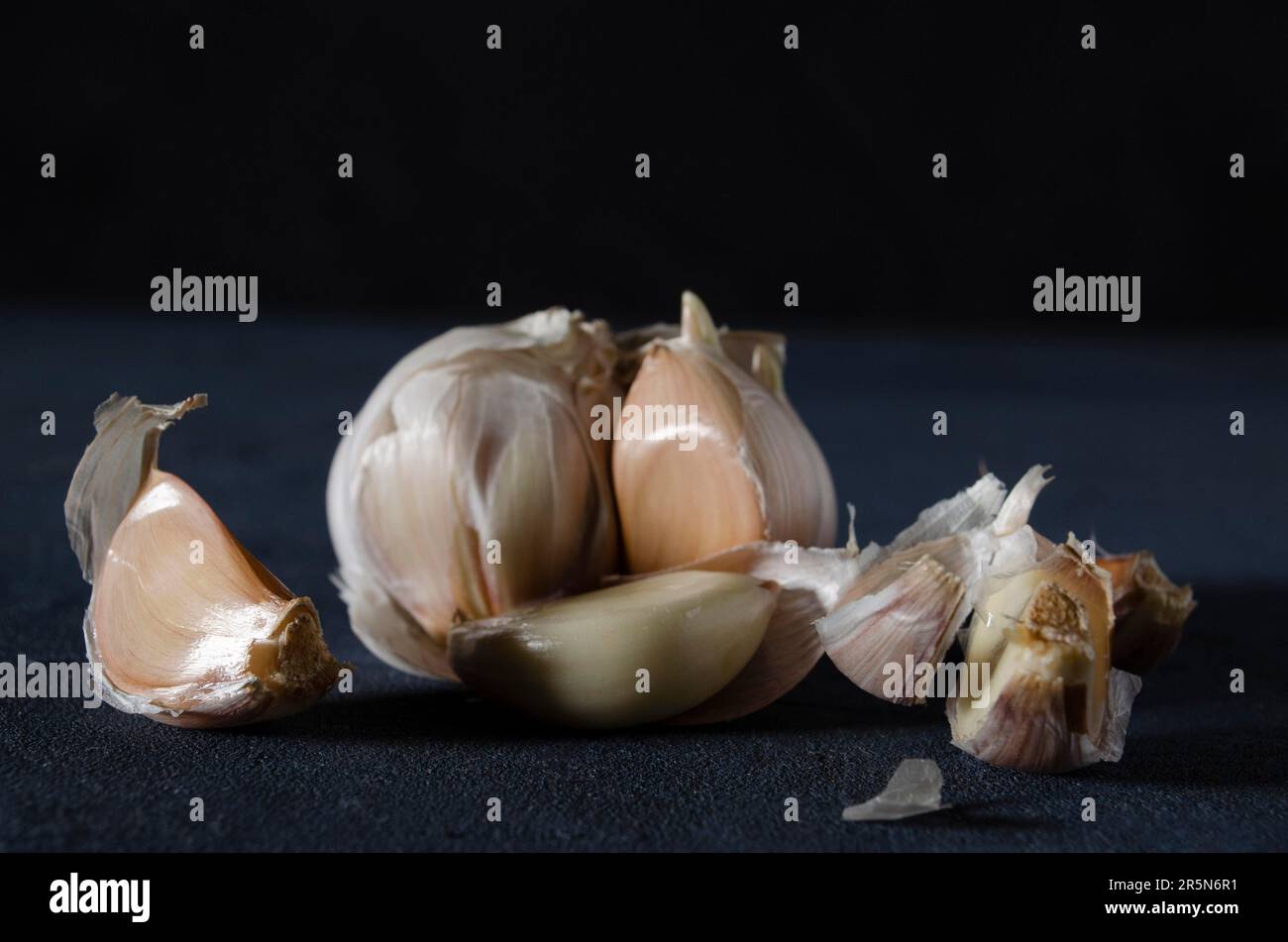The garlic, garlic cloves and skin on the dark background Stock Photo ...