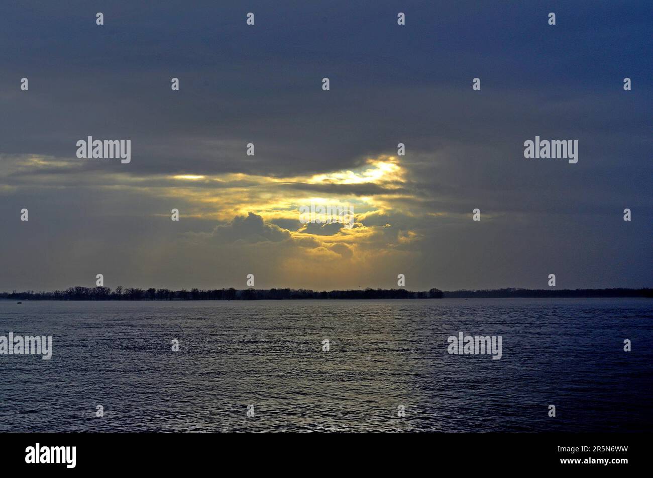 Storm over the river. Heavy clouds over the water, a bright beam of ...