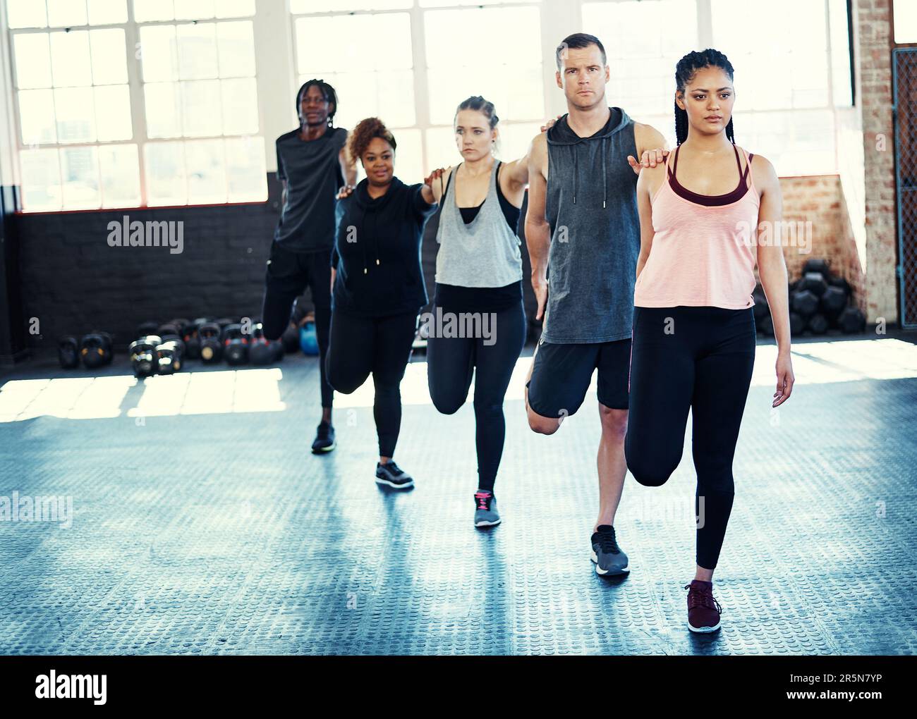 Stretching is important. a focused group of young people standing in a ...