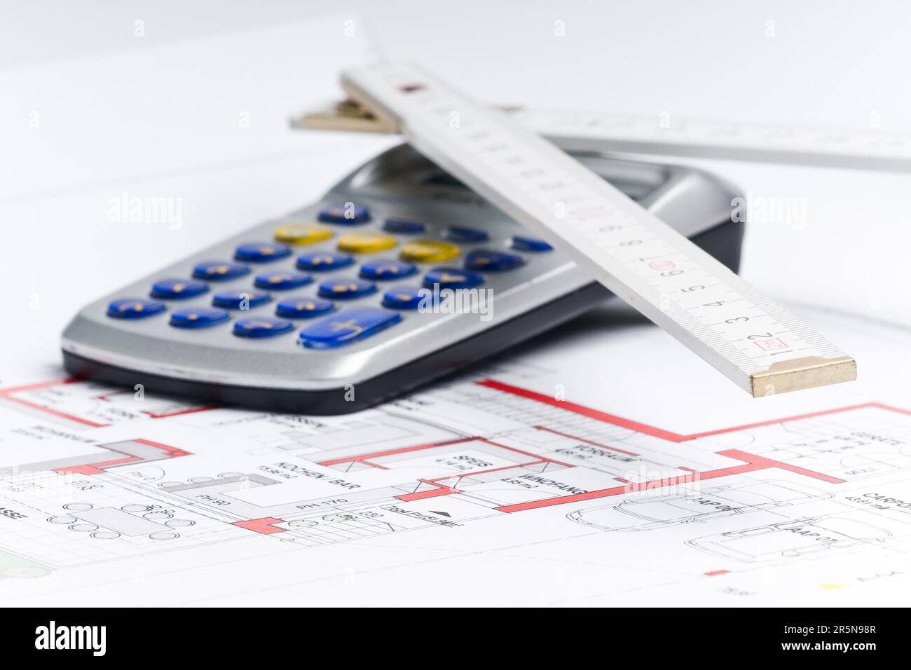 Calculator and ruler on a house plan for calculating Stock Photo - Alamy