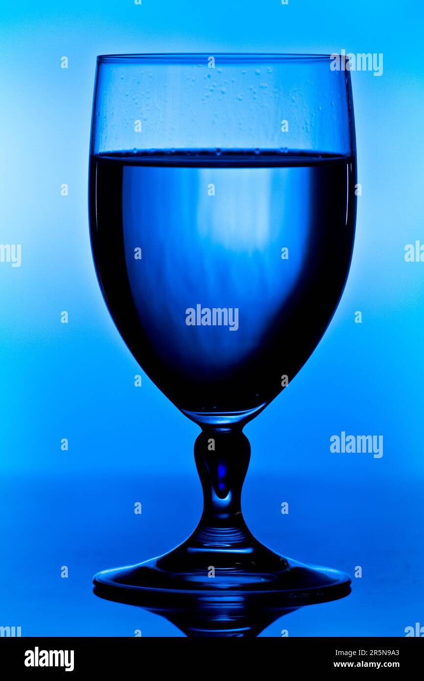 Glass water in front of blue background with strong contrast and ...