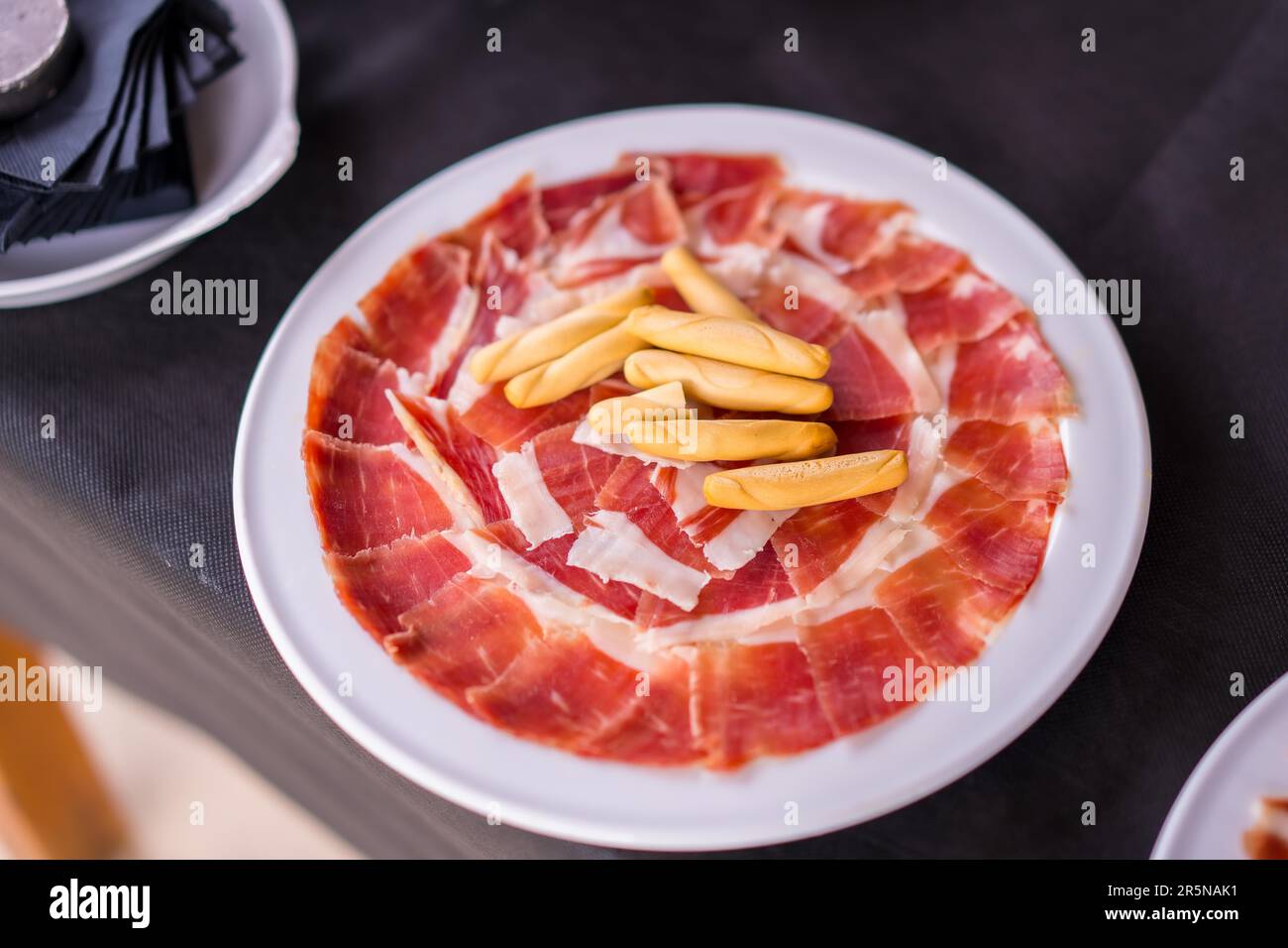 Dish with Iberico ham cut ready to eat. Ham cutter man. Service of a ...