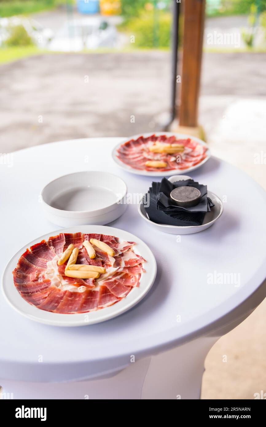 Dish with Iberico ham cut ready to eat. Ham cutter man. Service of a ...