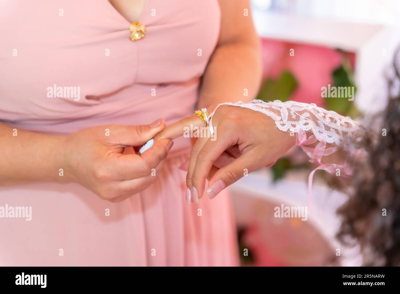 Mother placing a ring on her daughter on her 15th birthday, traditional ...
