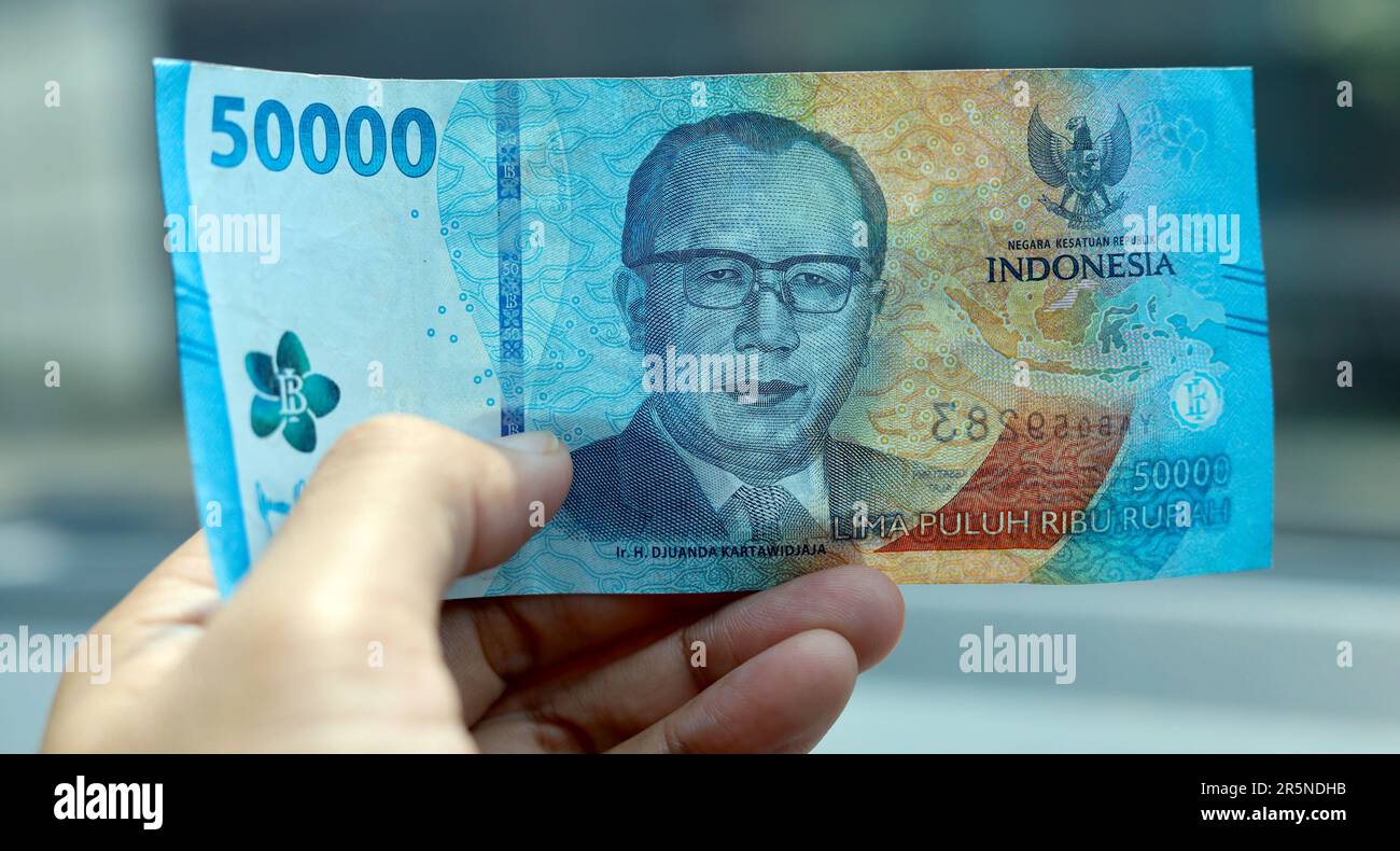 Indonesian man hand holding rupiah money. Indonesian currency. cash in ...