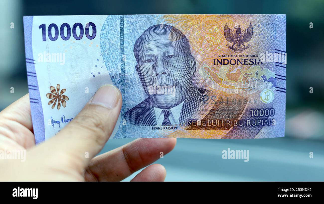 Indonesian man hand holding rupiah money. Indonesian currency. cash in ...