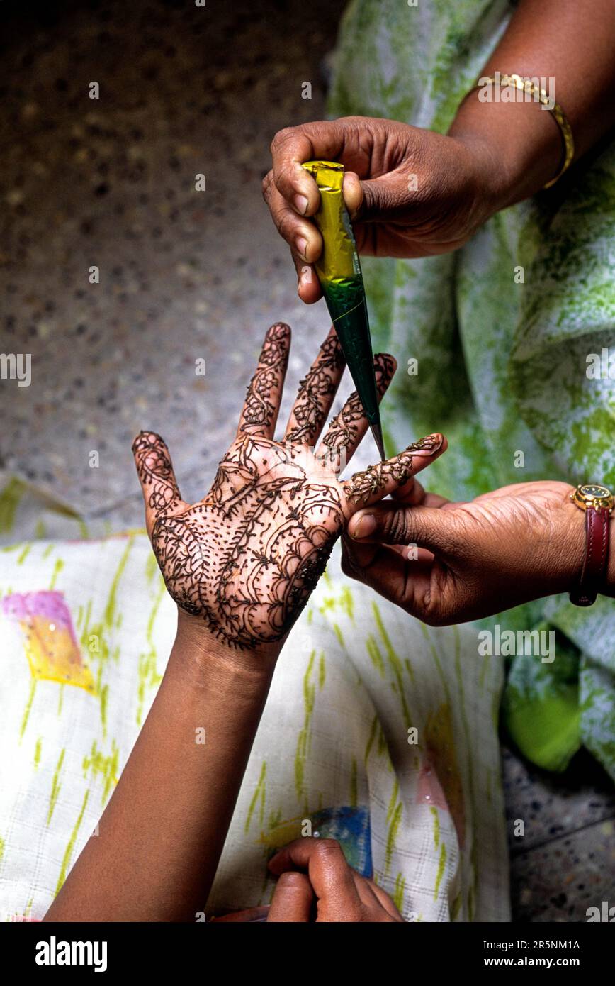 A woman showing mehandi henna applied on a girls hand, Tamil Nadu ...
