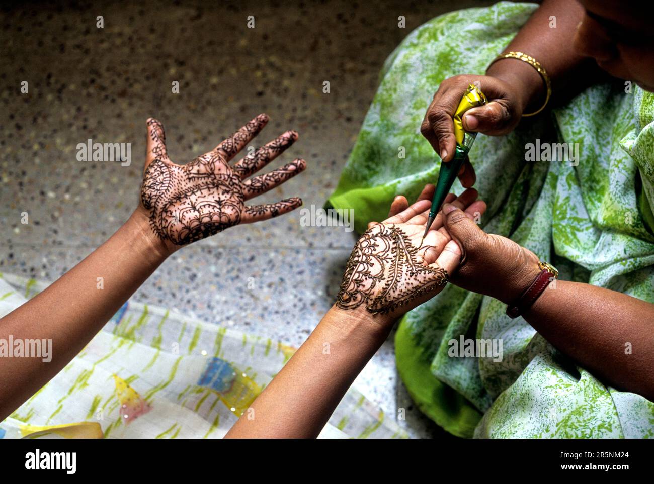 A woman showing mehandi henna applied on a girls hand, Tamil Nadu ...