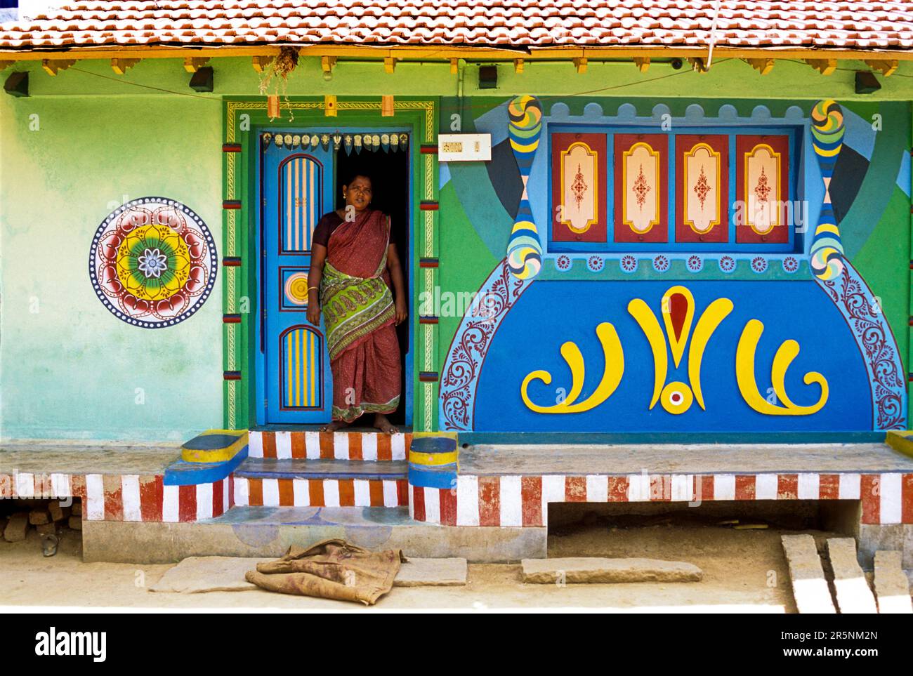 A woman standing at the entrance door of the village house, Tamil Nadu ...