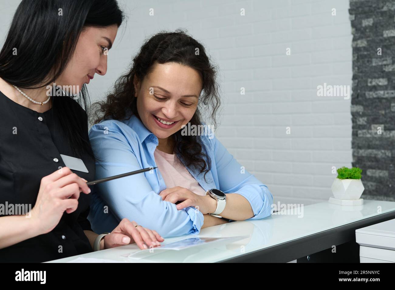 Female doctor prescribing treatment to patient, standing at reception ...