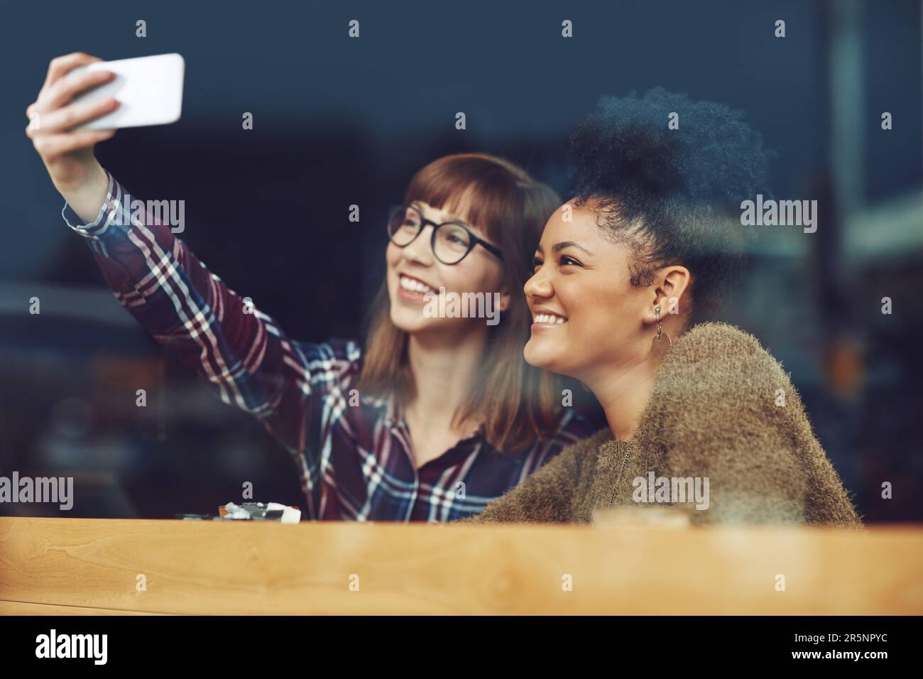 Theres no such thing as too many selfies. two young friends taking a selfie together in a cafe ...