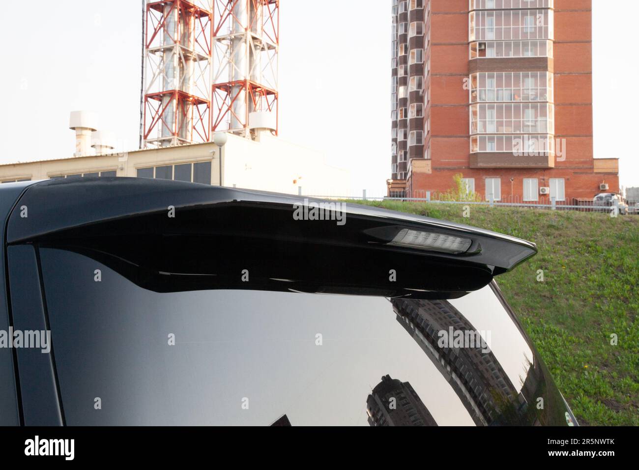 Close-up on the trunk lid of a black car with a plastic spoiler over ...