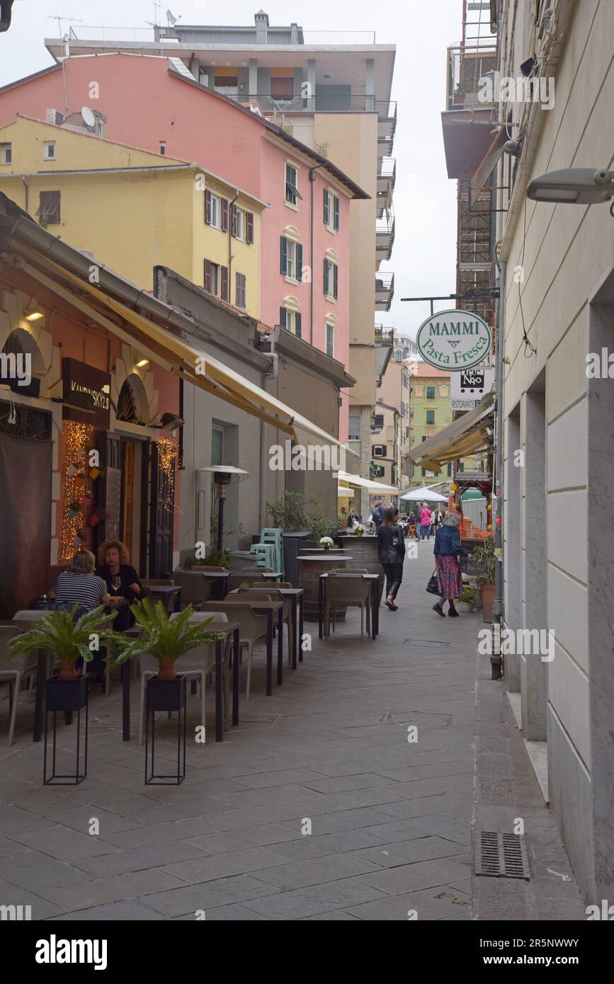 People shopping and dining at tables & chairs for cafes outdoors in ...