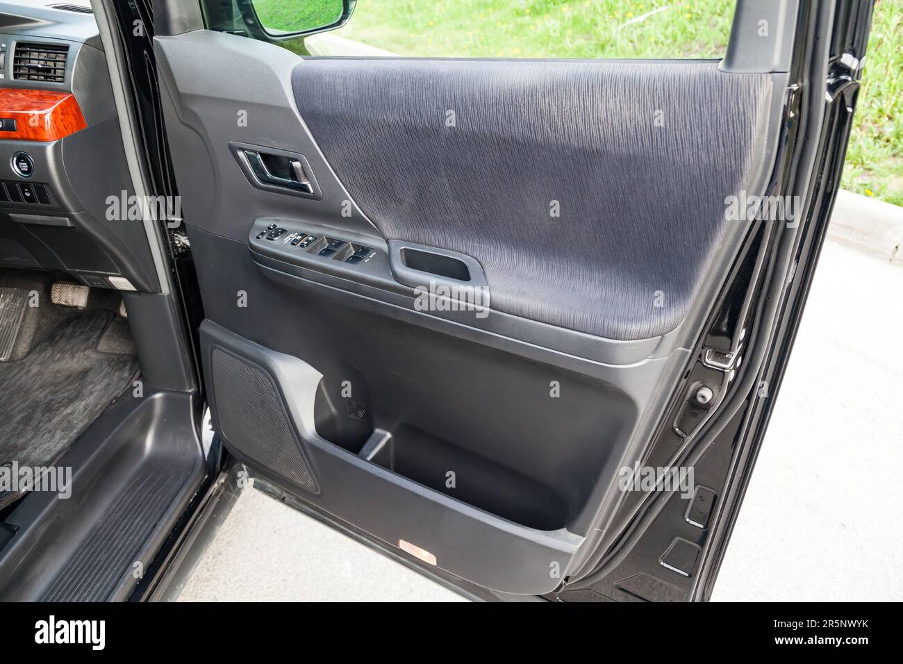 The open front door of a Japanese car with black plastic trim and a ...