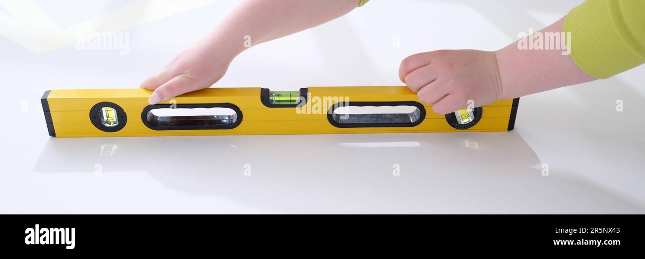 Working hands check evenness of wall with special tool for measuring ...
