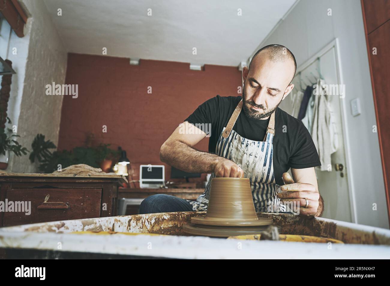 Let your art lead the way. a young man working with clay in a pottery ...