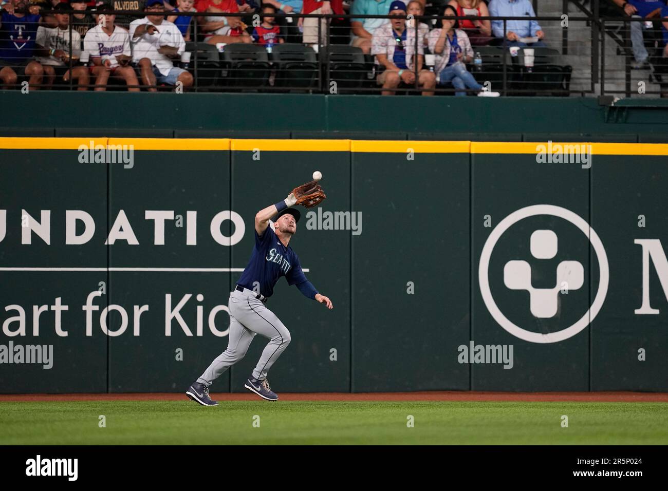 Seattle Mariners left fielder Jarred Kelenic reaches up to catch a fly ...