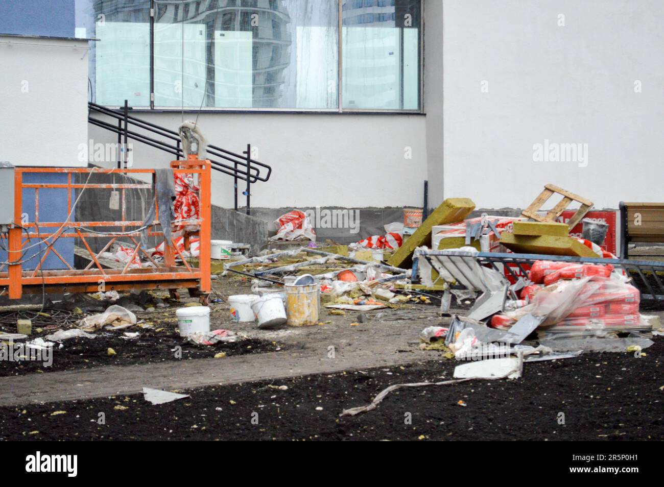 A mess at a construction site with scattered building materials and ...