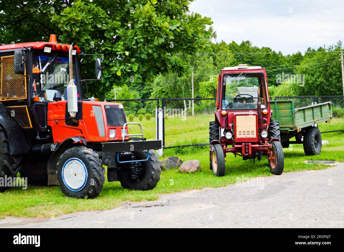 Two red professional agricultural construction tractor with large ...