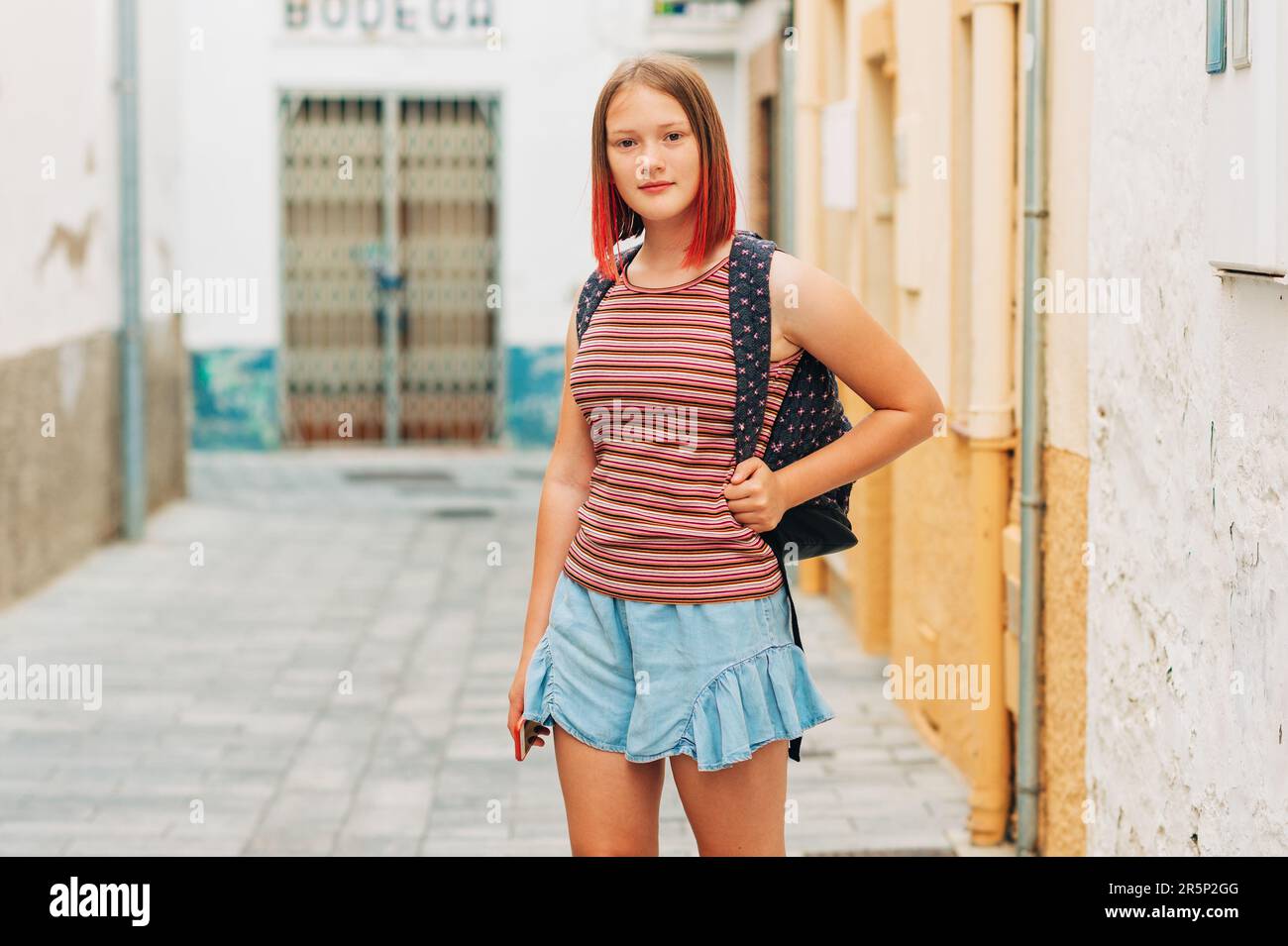 Outdoor portrait of pretty teenage girl with red dyed hair, wearing ...