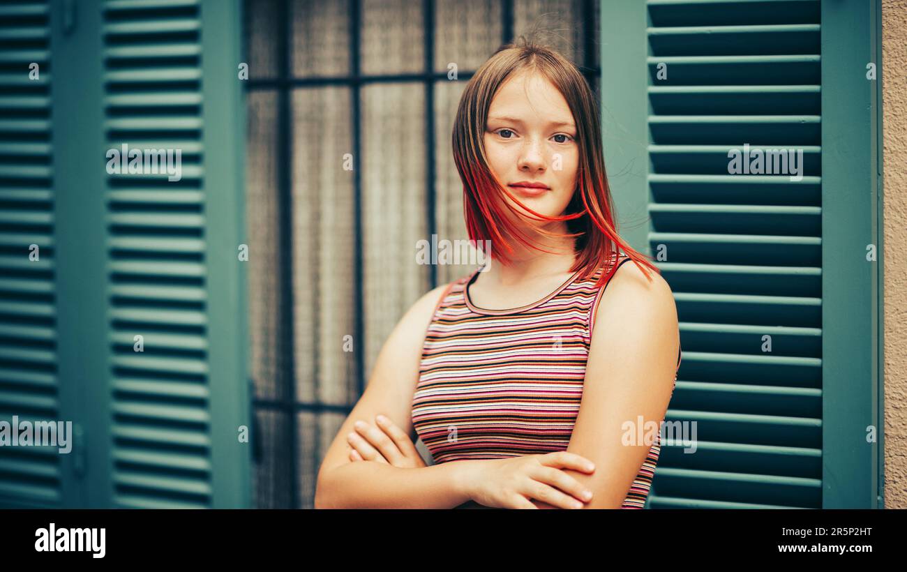 Outdoor portrait of pretty teenage girl with red dyed hair, wearing ...