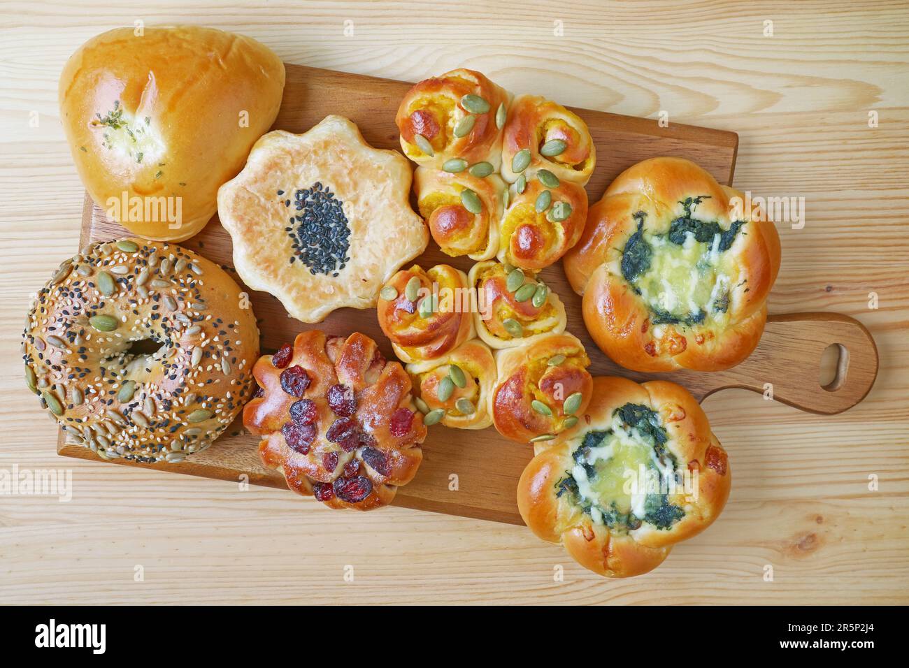 Mouthwatering assorted sweet and savory buns on wooden breadboard Stock ...