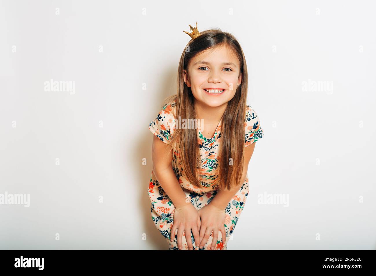 Studio portrait of pretty little girl wearing tiny princess crown ...