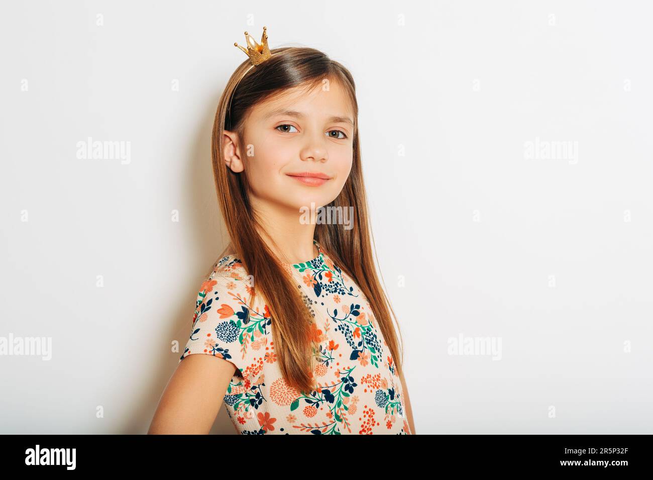 Studio portrait of pretty little girl wearing tiny princess crown ...