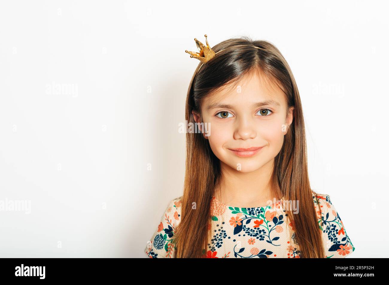 Studio portrait of pretty little girl wearing tiny princess crown ...