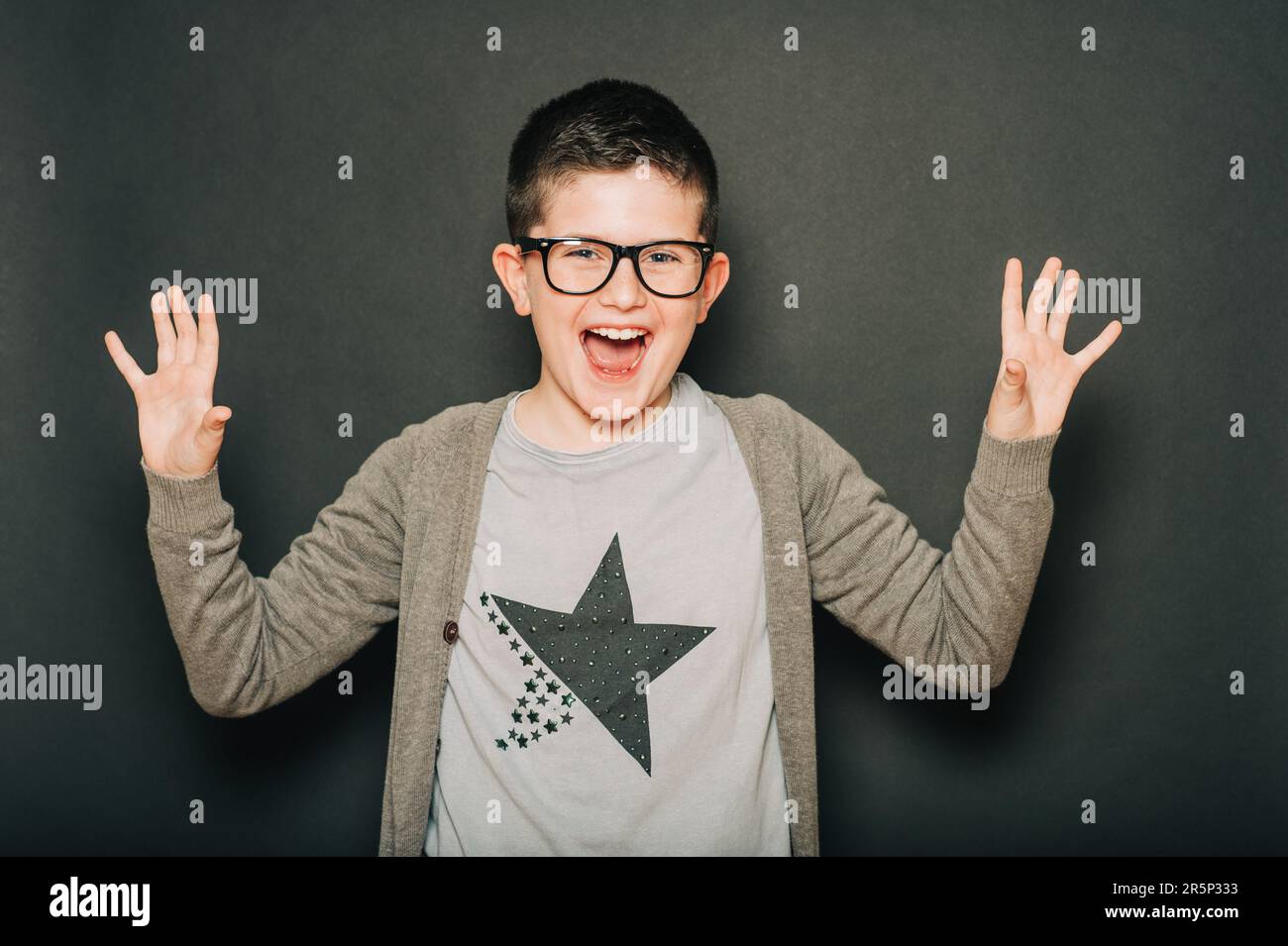Studio portrait of handsome young boy posing on black background ...