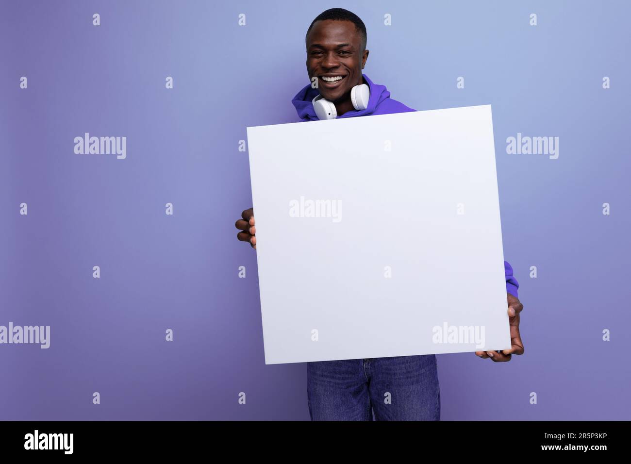 positive young african man with big flyer on background with copy space ...