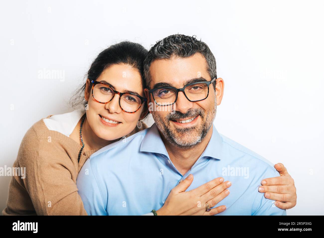 Studio portrait of happy couple wearing eyeglasses, posing together on ...