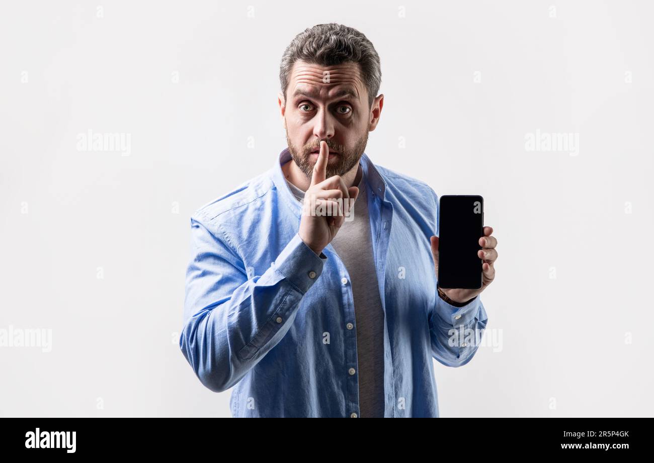 secret man showing phone app isolated on studio background. man showing ...