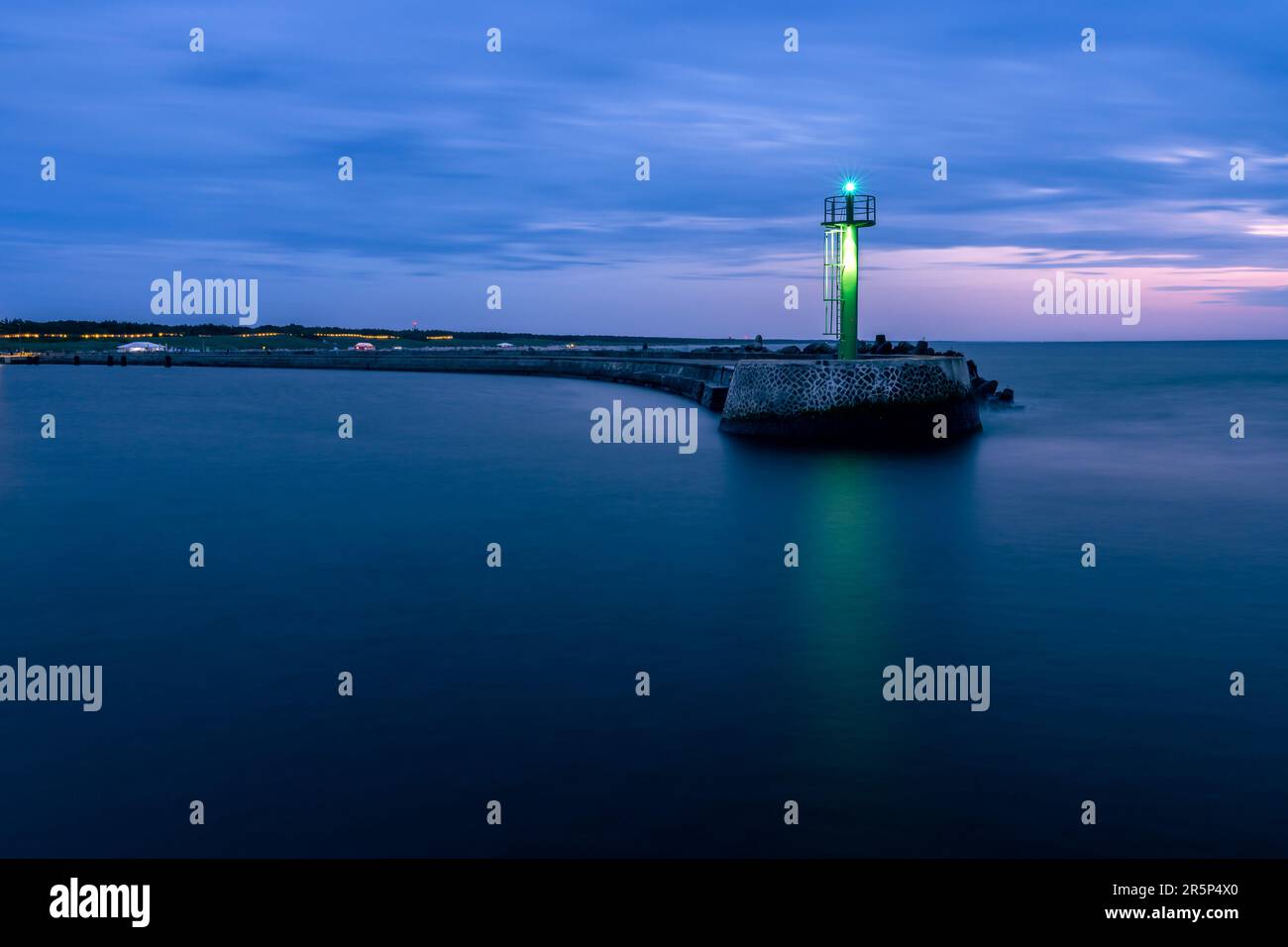 Stone pier in Darłowo in the evening. Lights on the beach. Traffic ...