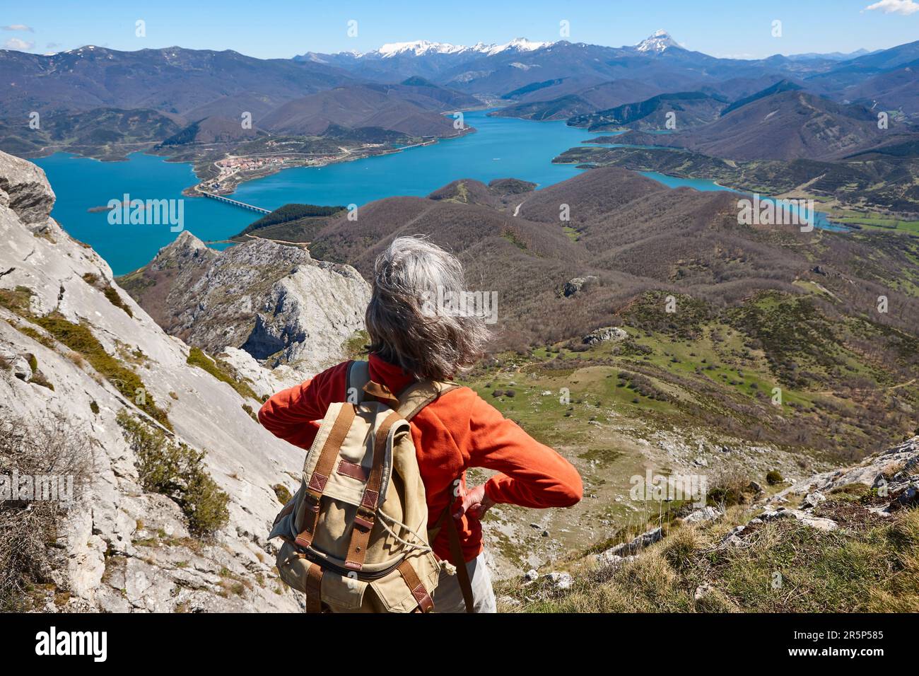 Picturesque reservoir and mountain range landscape in Riano. Hiker ...