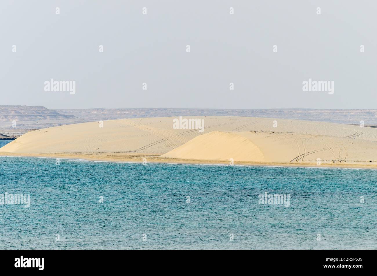 Sand dunes descending into the creek with limestone hills in the ...