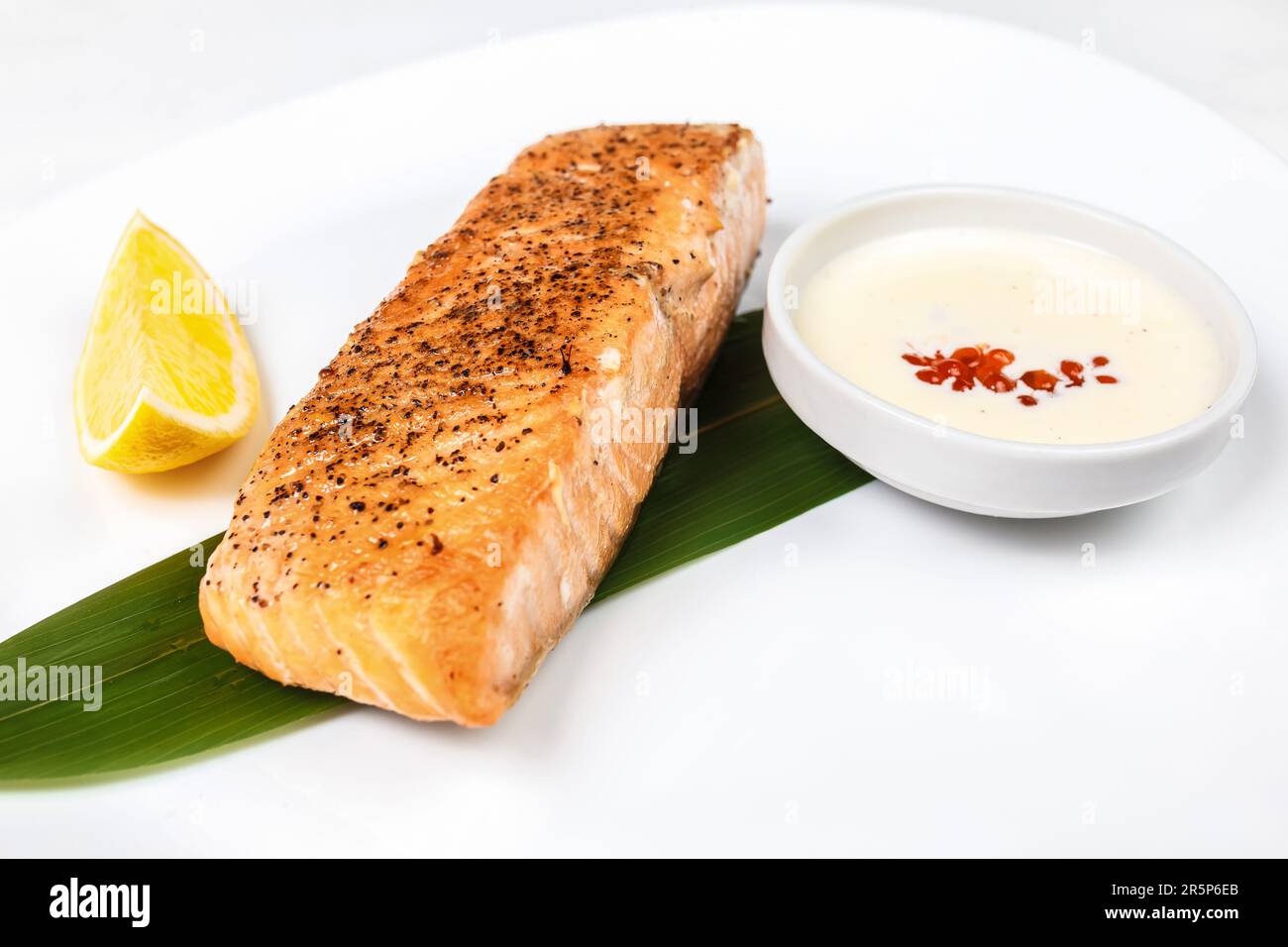A plate of grilled fish with lemon and roasted vegetables, a classic ...