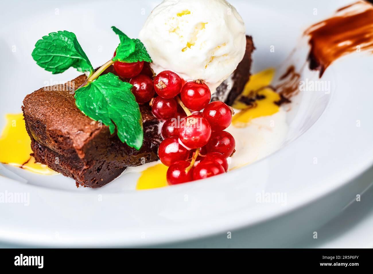 A cold dish of sweet, healthy berries over creamy vanilla ice cream is ...