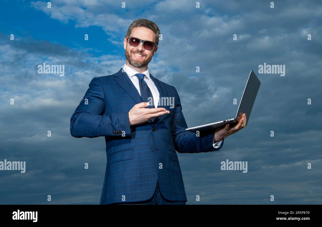 Happy QA engineer presenting product pointing at laptop. QA ...