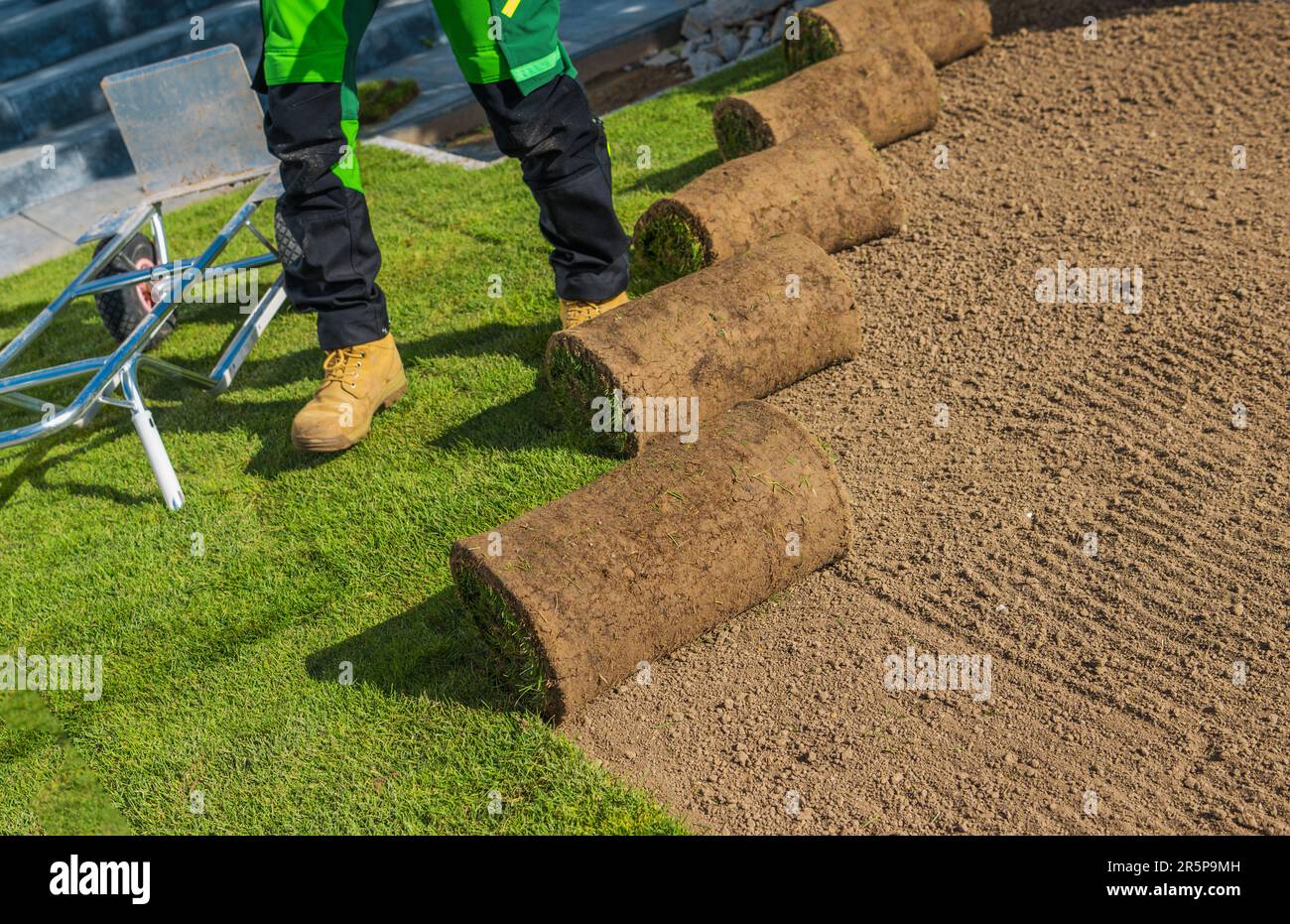 Natural Grass Turfs Installation in a Back Yard Garden. Seasonal Lawn ...