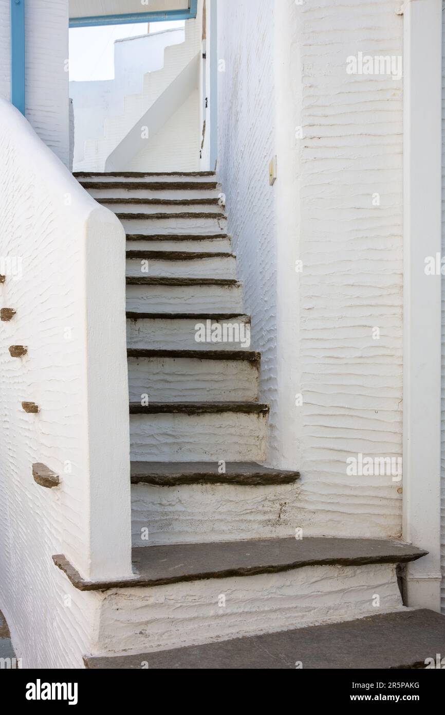 White painted old narrow stair background covered with stone between ...