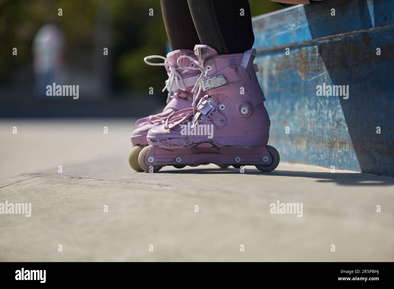 Aggressive inline skater girl tying laces on modern roller blades in a ...