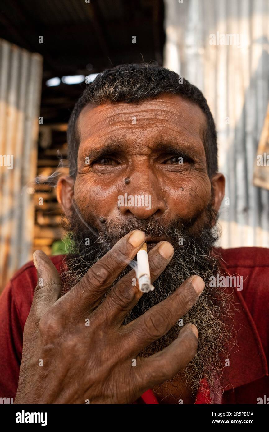 Portrait of a Bangladeshi man smocking a ciggerate. Pratab Nagar ...