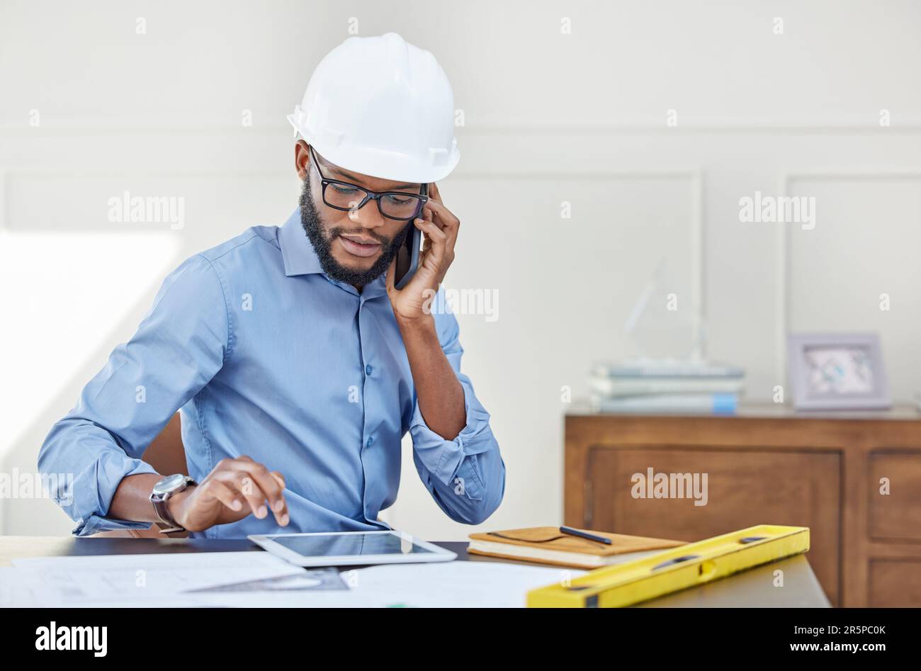 Planning, man architect with smartphone and tablet at his desk in his ...