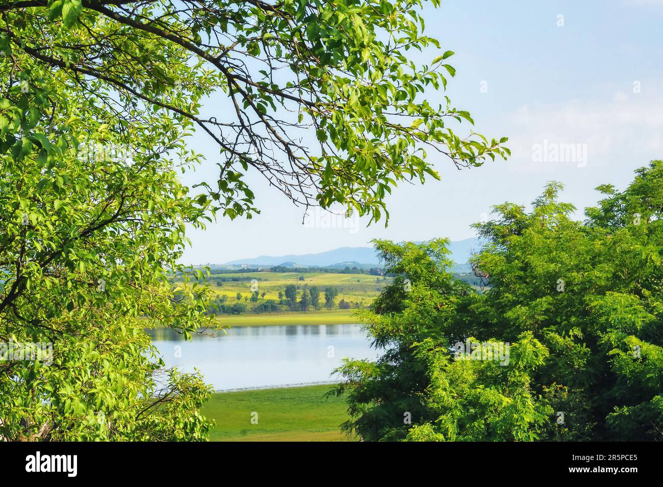 countryside lake in summer. mountainous rural area with village in the ...