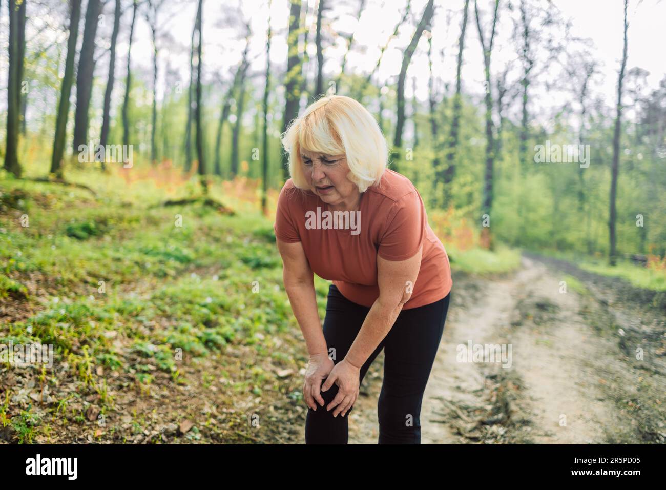 50s 60s fitness woman runner feel pain on knee. Outdoor exercise ...