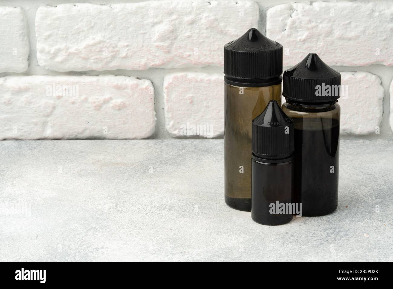 Refill liquid for electronic cigarettes against brick wall background ...